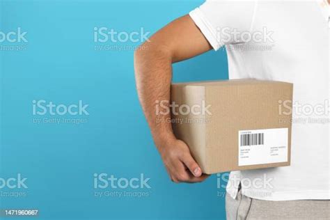 밝은 파란색 배경에 골판지 상자를 들고 있는 택배 근접 촬영 텍스트를 위한 공간 소포에 대한 스톡 사진 및 기타 이미지 소포