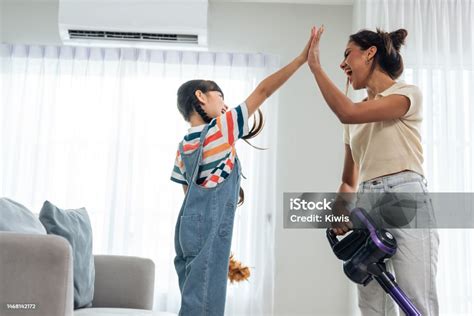 백인 아름 다운 어머니는 어린 아이 딸과 함께 집을 청소합니다 매력적인 아름다운 엄마는 집안일과 집안일을 위해 지저분한 더러운 바닥을 진공 청소기로 청소하는 사랑스러운 소녀