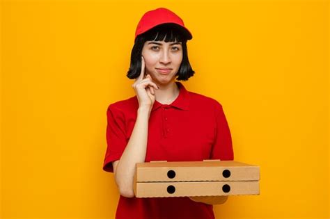 Free Photo Pleased Young Caucasian Delivery Girl Holding Pizza Boxes