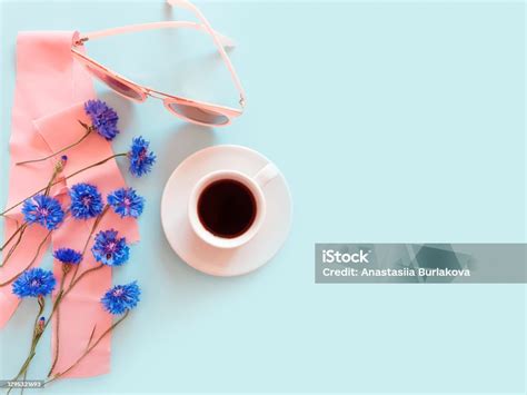 파스텔 블루 배경에 파란색 옥수수 꽃 핑크 선글라스와 핑크 실크 리본 커피 컵의 최고 보기 여름 해변 플랫 레이 여름에 대한
