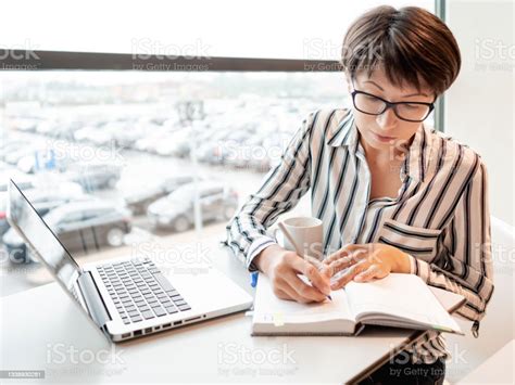 비즈니스 우먼은 공동 작업 센터에서 노트북 및 종이 주최자와 함께 일합니다 비즈니스 센터의 프리랜서를 위한 직장 계획에 대한 스톡 사진 및 기타 이미지 Istock