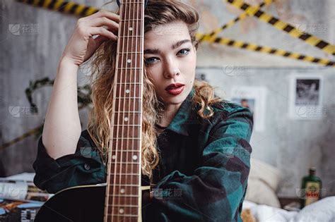 摇滚小鸡的主题。漂亮的白色女性金发，穿着牛仔裤和黑色细带子上衣