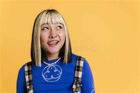 Asian Girl With Piercing Showing Her Tongue And Looking Aside Stock