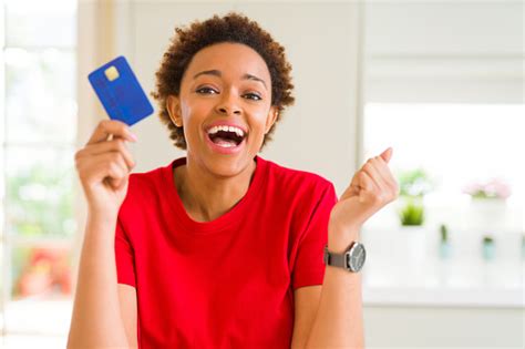 신용 카드를 들고 젊은 아프리카 계 미국인 여성 자랑 스럽게 비명을 지르고 승리와 성공을 축하 하는 매우 흥분 응원 감정 사람들에 대한 스톡 사진 및 기타 이미지 Istock