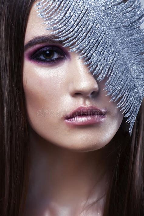 Beauty Brunette Young Girl With Fashion Makeup And Silver Feather