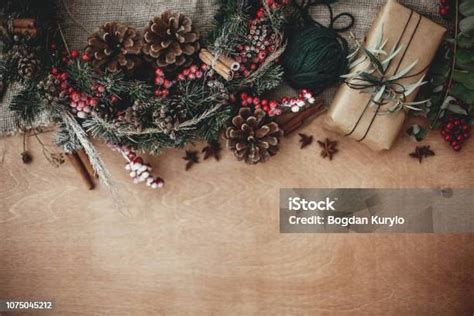 세련 된 소박한 선물 상자 녹색 지점 및 화 환 전나무 아니 스 소나무 콘 딸기 소박한 나무 바탕에 계 피 텍스트를 위한