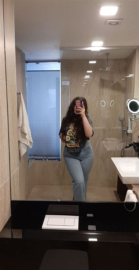 A Woman Taking A Selfie In A Bathroom Mirror