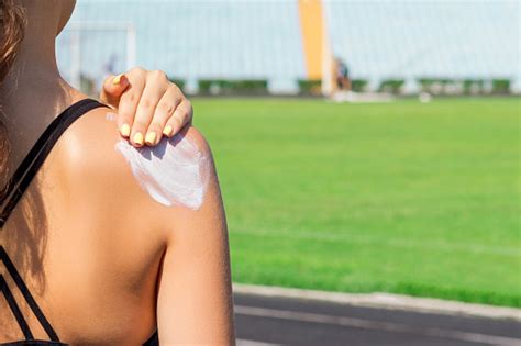 젊은 여성 주자 서 손에 태양 로션을 퍼 팅 여름 아침에 스포츠 실행 운동 하기 전에 Sunscream을 사용 하 여 소녀 스포츠와 건강 한 컨셉 햇볕 차단 로션에 대한