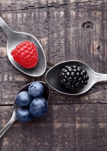 Premium Photo Raspberry Blueberries And Blackberry On Spoons