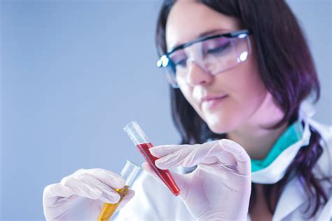 의료 개념 보호 장갑을 사용하여 액체 화학 물질을 포함하는 플라스크를 다루는 여성 실험실 노동자 수평 샷 20 29세에 대한