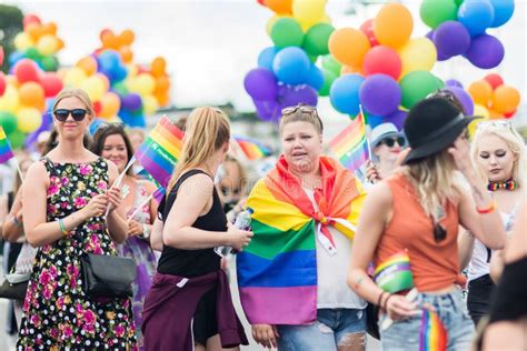 Two Men Holding A Rainbow Umbrella Attending The Gay Pride Parade Also