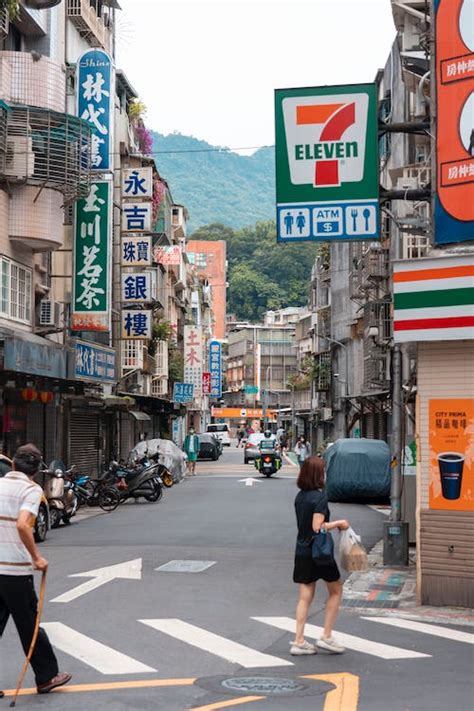 7 일레븐 거리 건너는 건물 걷고 있는 남자 도시 도시 거리 도시의 상점 소도시 수직 쐈어 여성 횡단