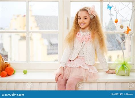 Beautiful Young Girl Sitting On A Windowsill At Cozy Home Atmosphere