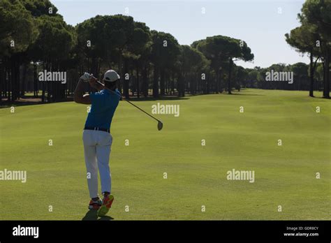 Golf Player Hitting Shot With Club On Course At Beautiful Morning With