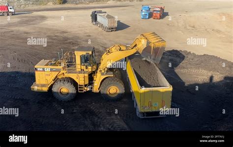 Wheel Loader Loading Soil On Trucks Working At A Huge Mining Site