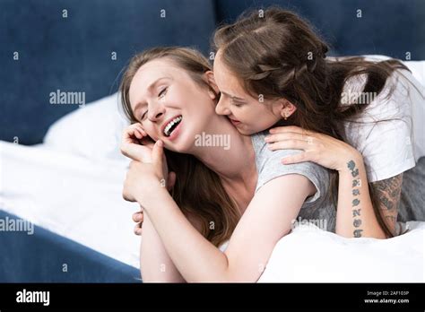 Two Lesbians Embracing With Closed Eyes While Lying On Bed In Morning