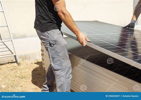 Close Up Of A Worker S Hands Tying A Stack Of Solar Panels With Orange