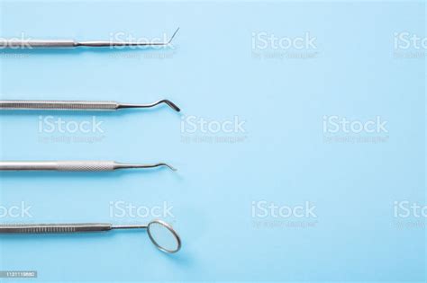 치과 의사 도구 자유로운 공간을 가진 밝은 파랑 배경에 거울을 가진 직업적인 강철 치과 계기 치아 건강과 티 케어 개념 강철에