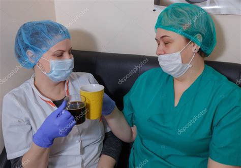 Una doctora con una máscara estéril y uniforme en un descanso durante la pandemia del