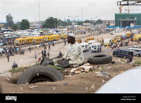 Lagos Nigeria On Old Man Sits By The Roadside Overlooking A Bus
