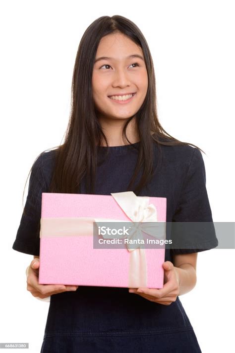 행복 한 아시아 십 대 소녀가 웃 고 생각 하면서 선물 상자를 들고 십대 소녀에 대한 스톡 사진 및 기타 이미지 십대 소녀