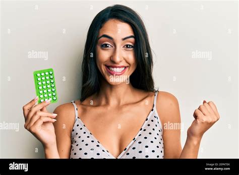 Beautiful Hispanic Woman Holding Birth Control Pills Screaming Proud