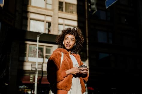 Premium Photo Cheerful Black Woman Listening To Music While Walking In Downtown