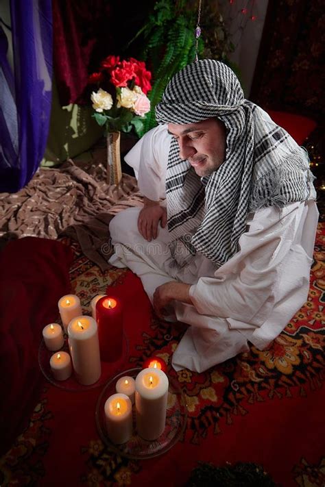 Arab Sheikh In A White Robe And A Headscarf In A Boudoir In A Room With