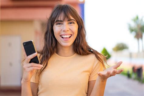 Premium Photo Young Woman Using Mobile Phone At Outdoors With Shocked
