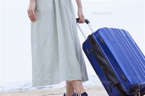 スーツケースを持って海辺に佇む日本人女性の写真素材 FYI07523330 ストックフォトの Qlean Market