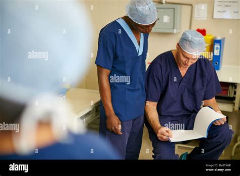 Double Checking The Patients Stats Before The Operation Surgeons Going Through Paperwork In