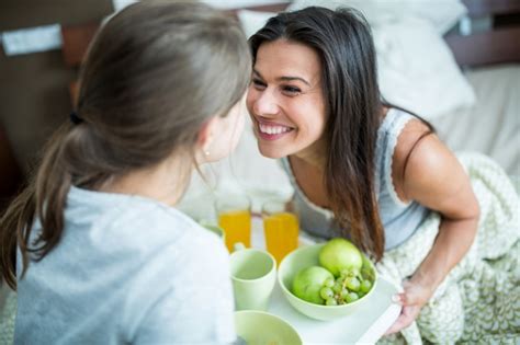 Mãe e filha tomando café da manhã na cama Foto Premium