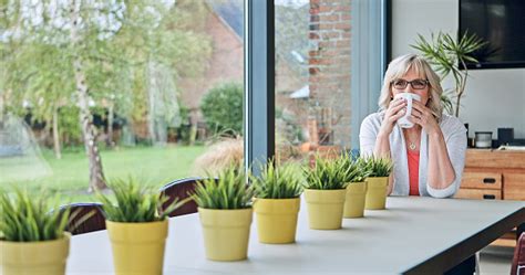 부엌에서 노인 여성 커피와 함께 휴식을 취하고 생각 차분한 아침과 테이블에 앉아 집 아침 식사 음료 티타임에 고령자 추억 반성 통찰력이 있는 아파트 65 69세에 대한 스톡