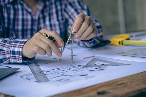 건설 현장에서 새 프로젝트를 진행하는 엔지니어 또는 건축가 청사진을 사용하고 노트북을 사용하면 건축 엔지니어의 개념으로 프로젝트