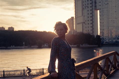 Premium Photo Woman Standing Against River In City During Sunset