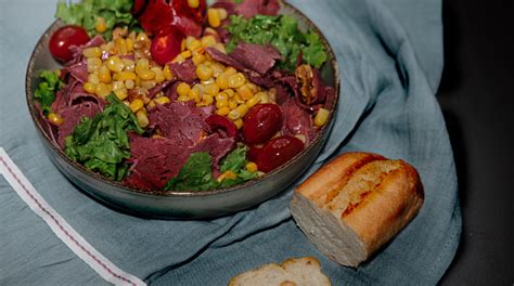 채소 양상추 옥수수 방울 토마토 프렌치 바게트 점심 간식 또는 저녁 식사로 델리 고기를 곁들인 가벼운 여름 샐러드로 얇게 썬 콜드 컷 쇠고기 고기 어두운 배경 0명에 대한