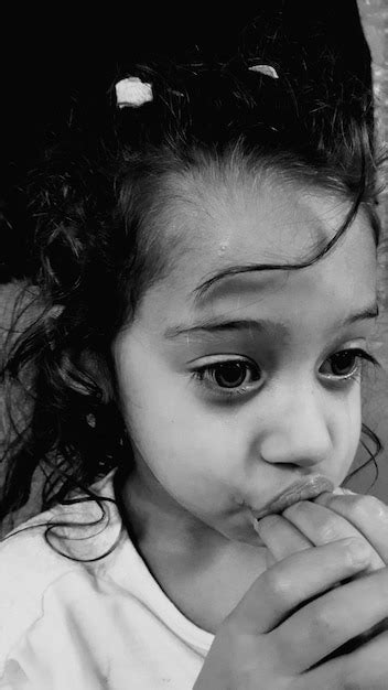 Premium Photo Close Up Of Innocent Girl With Hand In Mouth