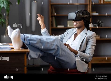 Curious Afro Businesswoman In Vr Goggles Headset Touching 3d Virtual Objects Sit At Office