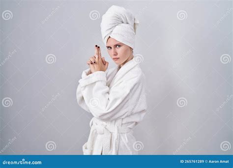 Blonde Caucasian Woman Wearing Bathrobe Holding Symbolic Gun With Hand