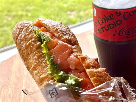 バゲットサンドスモークサーモン（セブン）；はかどらない草抜き中のランチ よく飲むオバチャン本日のメニュー