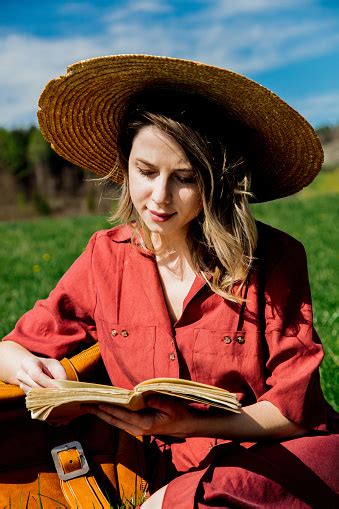 Beautiful Girl In Red Dress And Hat With Suitcase And Book Sitting On