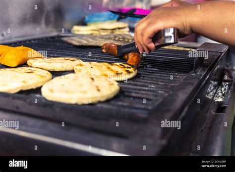 Selektive Nahaufnahme der Hände Chorizo und arepas vorbereiten Traditionelle