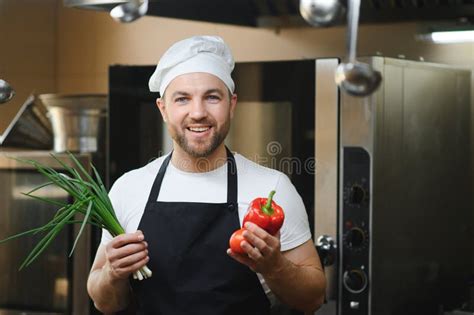 Portrait Of Handsome Positive Chef Cook At The Restaurant Kitchen Stock
