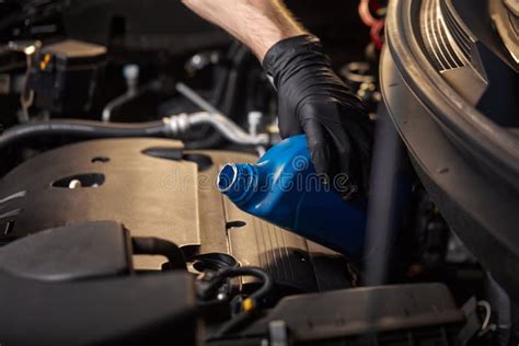 Mechanic Man In Gloves Pouring Oil Into Car Engine Closeup Stock Image