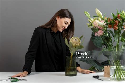 플로리스트는 플로럴 스튜디오에서 프로테아 꽃과 꽃의 줄기를 자르고 있습니다 배송을 위한 프로테아 꽃다발 만들기 구성을 만들기위한 준비 꽃 만들기에 대한 스톡 사진 및 기타