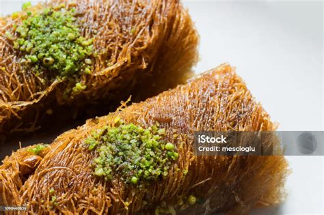 피스타치오 너트와 접시에 터키어 유명한 디저트 버마 Kadayif Shredded 반죽 시럽에서 구워 얹은 짓 눌린 견과류