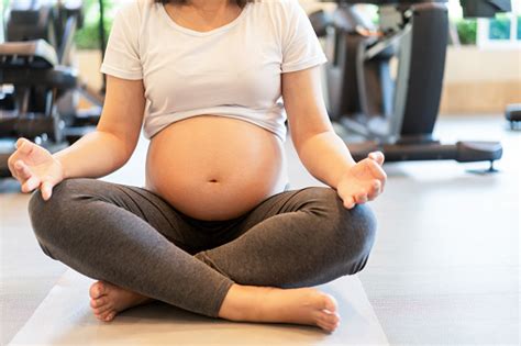 요가룸의 피트니스 센터에서 활동적인 임산부 운동을 합니다 임신 한 배에 아기를 들고 젊은 기대 어머니 출산 전 관리 및 여성 임신 개념 건강한 생활방식에 대한 스톡 사진 및