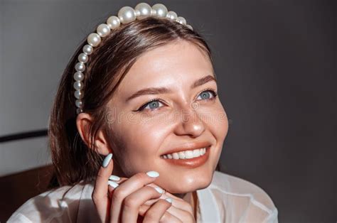 Pretty Woman With Pearl Jewelry In Hair Looks At The Camera And Smiles