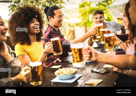Multicultural People Drinking And Toasting Beer Pint At Brewery Bar