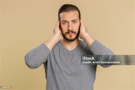 짜증나는 짜증 잘 생긴 남자 귀를 가리고 몸짓 피하지 않는 조언 소음 무시 큰 목소리 20 24세에 대한 스톡 사진 및 기타